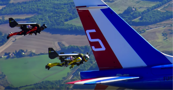 Three Men Use Jet Packs to Fly in Formation With Real Jets